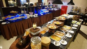 Mesa de buffet com diversos alimentos e utensílios.