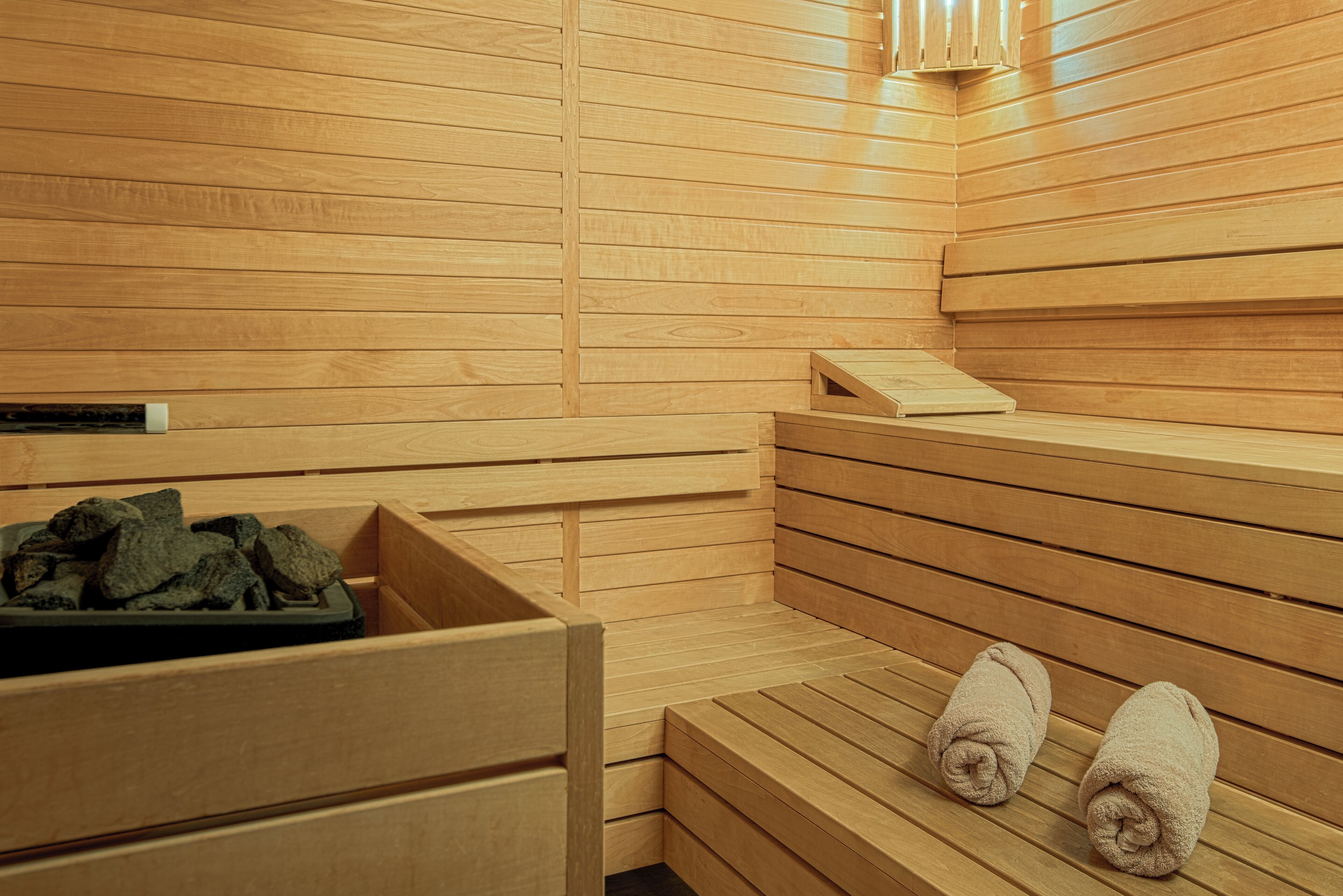 Uma sauna de madeira com bancos e um banco com toalhas.