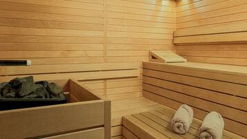 Uma sauna de madeira com bancos e um banco com toalhas.