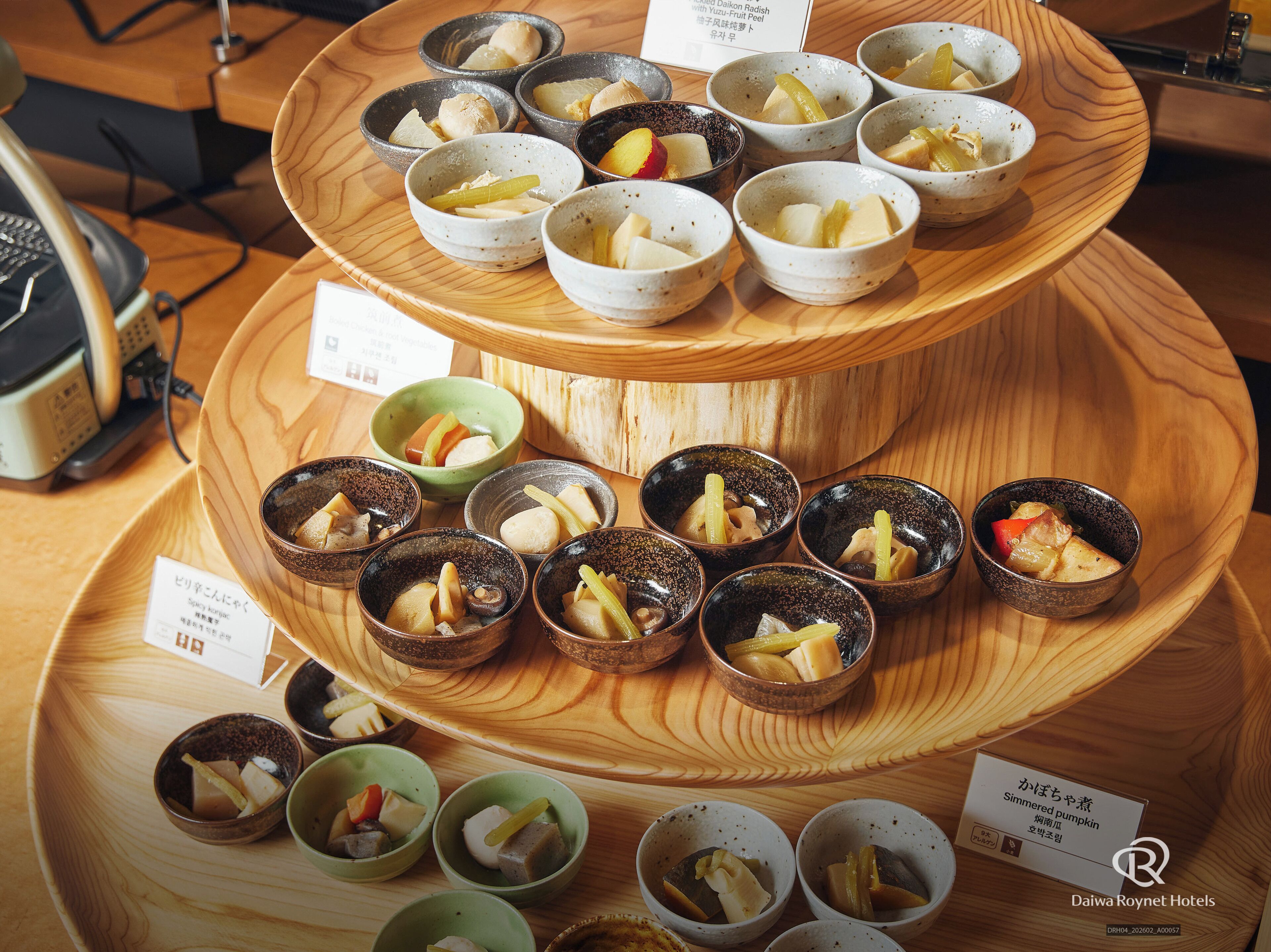 Exposição em vários níveis de diversos alimentos em pequenas tigelas, dispostas sobre uma mesa de madeira.
