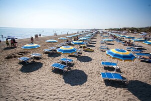 Uma praia privada, espreguiçadeiras, guarda-sóis de praia 