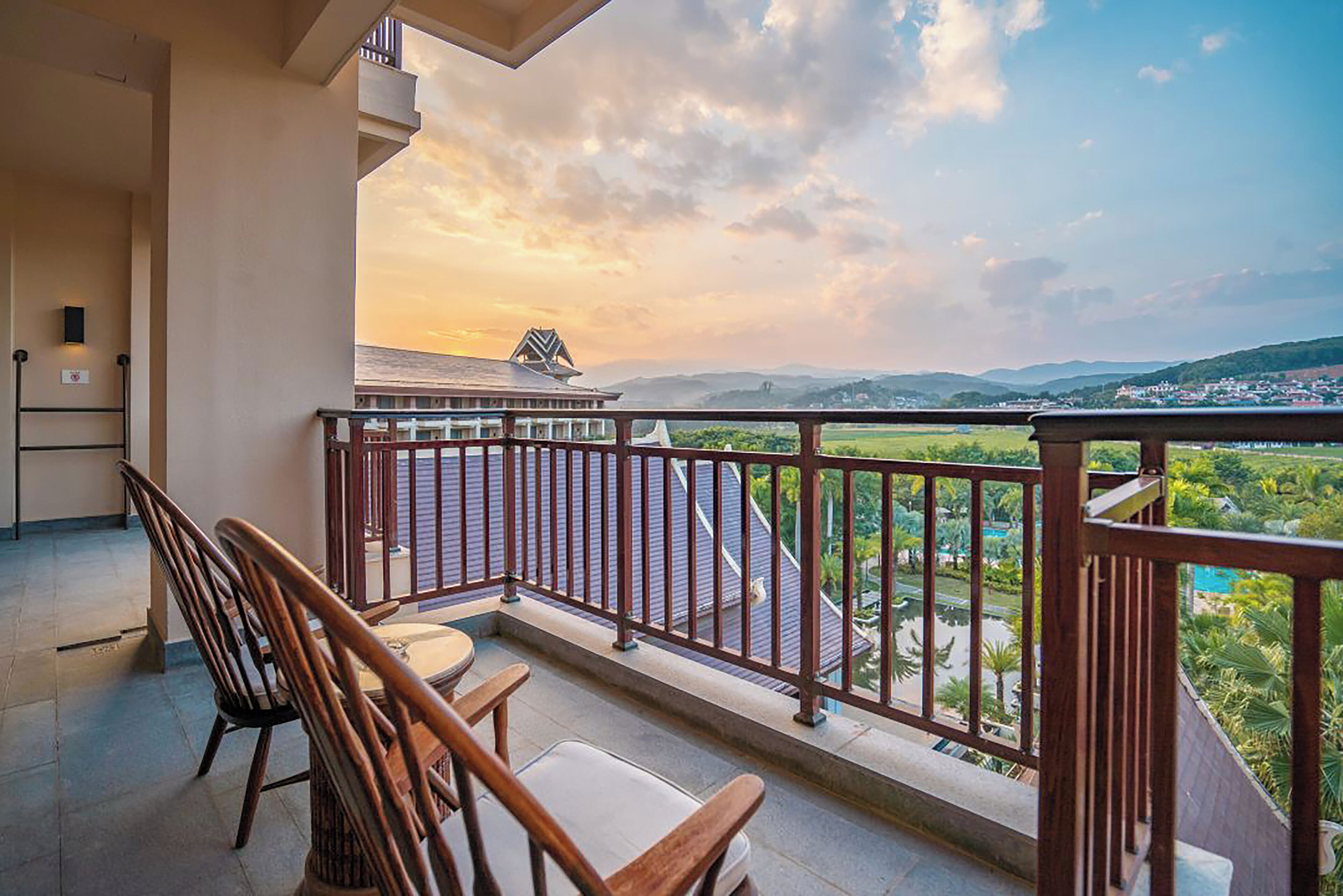 Varanda com vista para um edifício distante e paisagem.