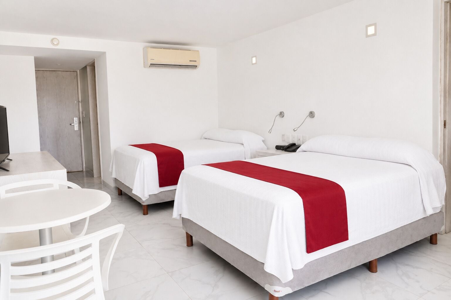 Quarto de hotel com duas camas, uma escrivaninha e uma cadeira.