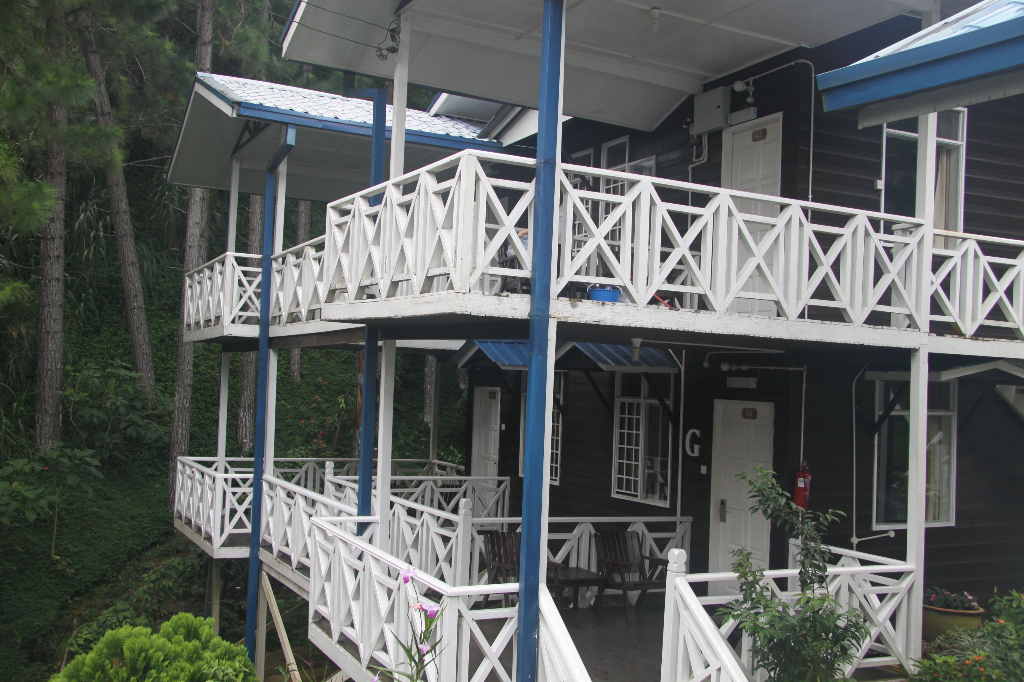 Um edifício de dois andares com varanda e alpendre coberto.