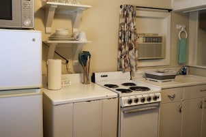 Cozinha compacta com micro-ondas, fogão e pia.