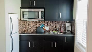 Um frigorífico/congelador grande, um micro-ondas, uma placa de cozinha