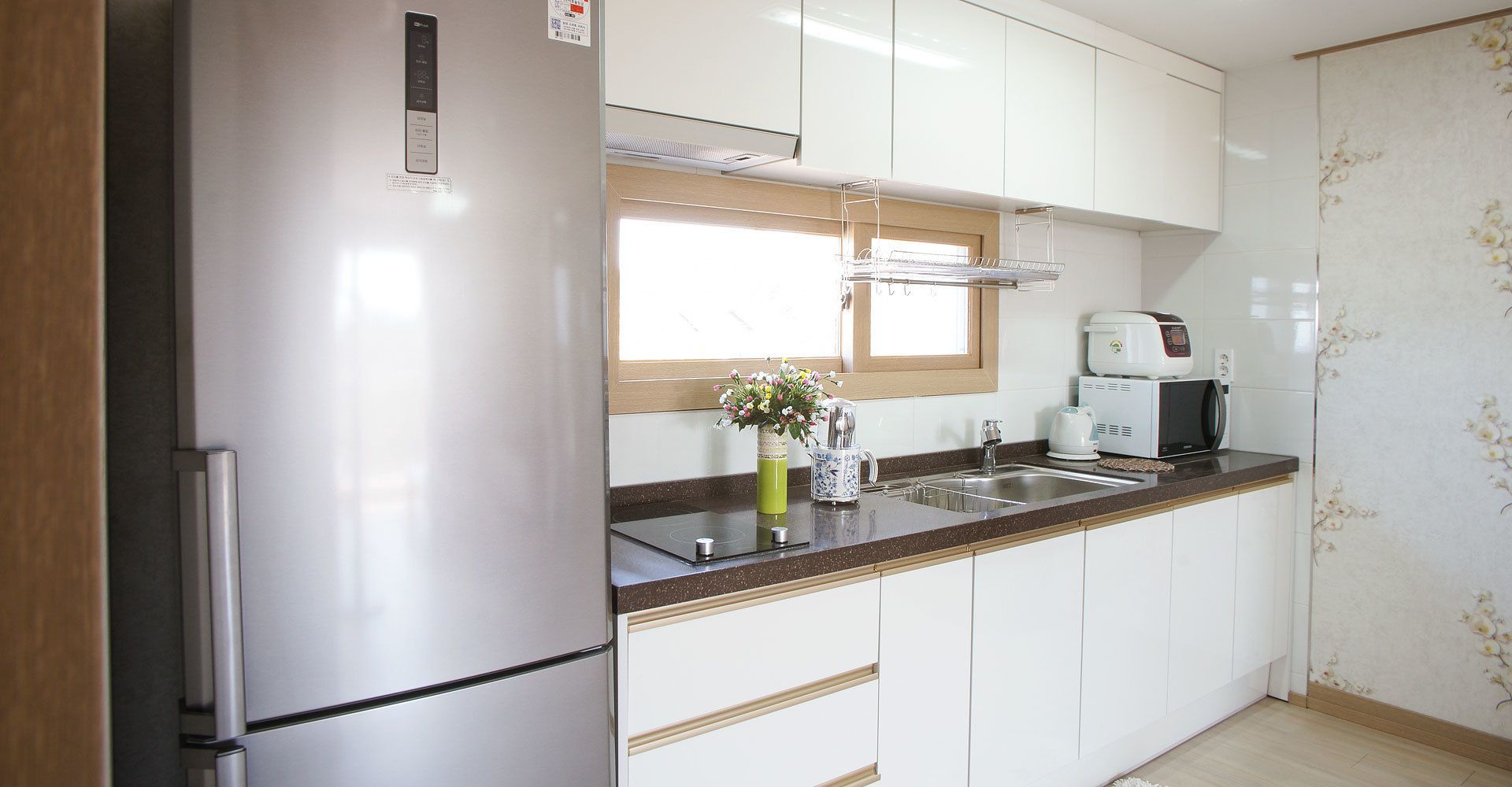 Um frigorífico/congelador grande, um micro-ondas, uma placa de cozinha 