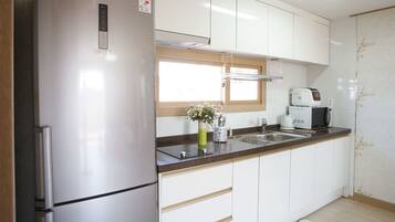 Um frigorífico/congelador grande, um micro-ondas, uma placa de cozinha