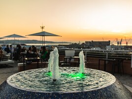 Bar no terraço com fonte de água e área de estar externa.