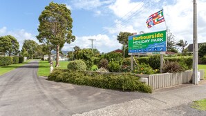 Placa do Harbourside Holiday Park com comodidades como piscina, sala de TV e churrasqueira.