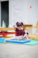 Criança brincando com brinquedos num tapete.