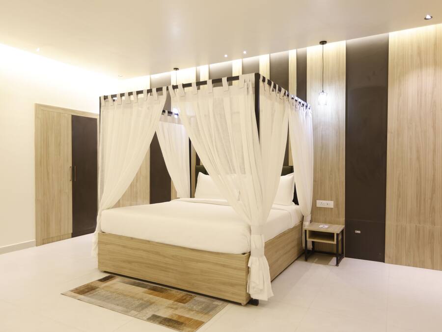 Quarto moderno com uma cama de dossel, uma pequena mesa de cabeceira e um criado-mudo.