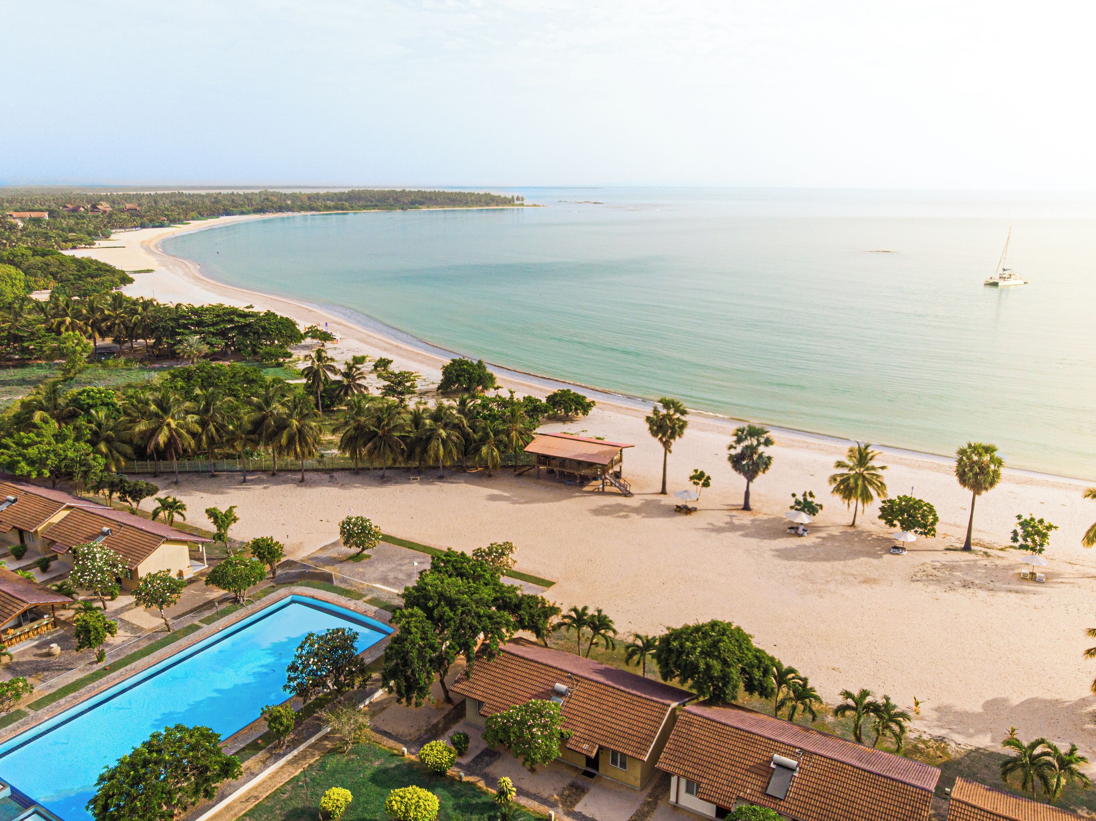 Um resort com piscina, praia e vista para o oceano.
