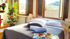Quarto com cama, bandeja de café da manhã e vista para o exterior.