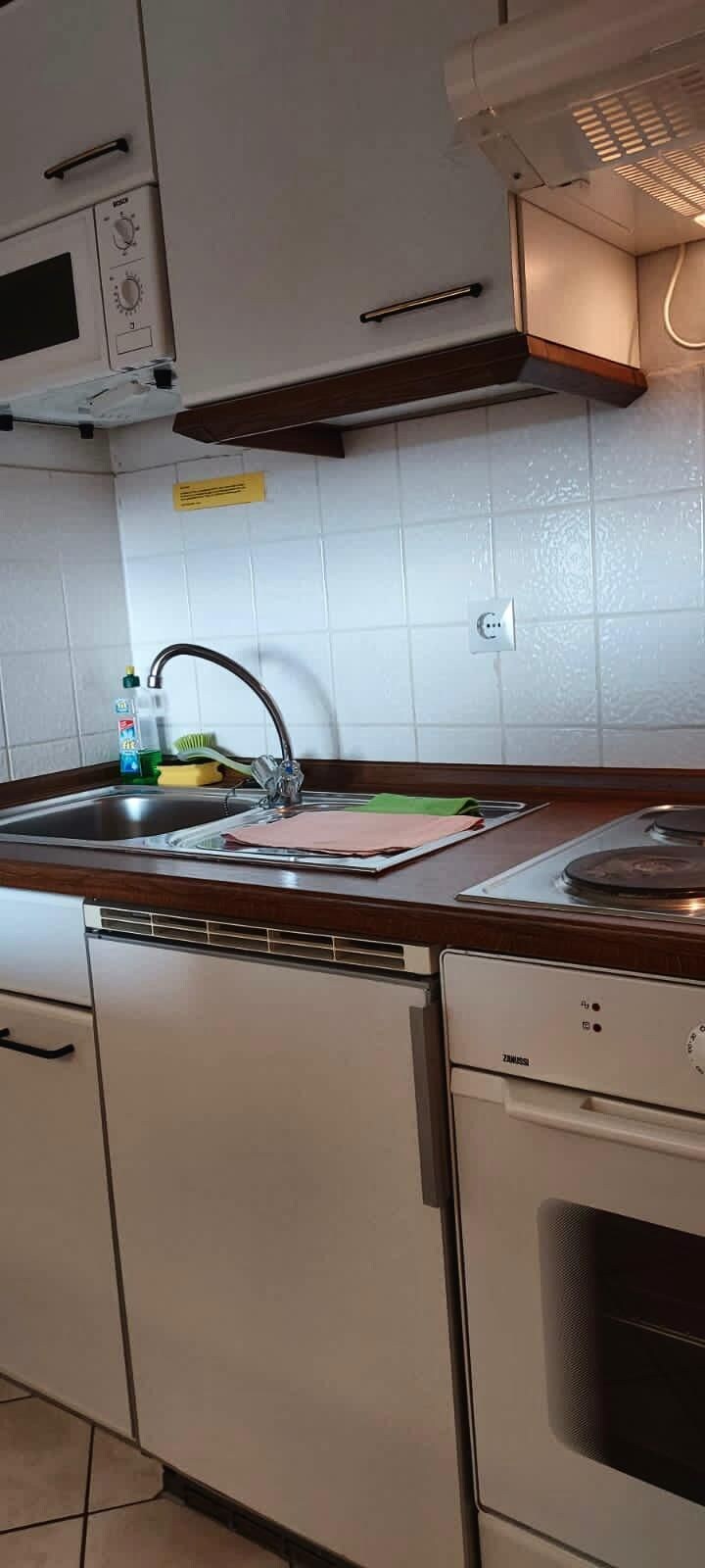 Uma cozinha com pia, fogão e armários.