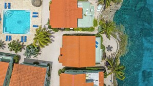 Vista aérea de um resort com vários edifícios, uma piscina e uma praia.