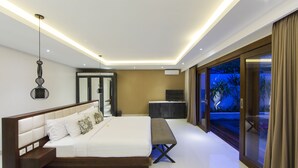 Quarto moderno com uma cama grande, um banco, uma TV e uma porta de vidro deslizante para o exterior.