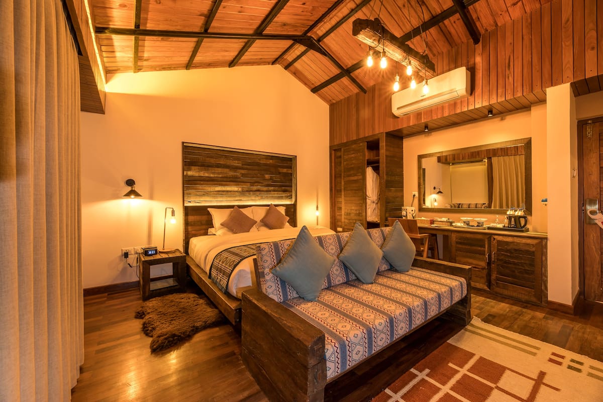 Um quarto aconchegante com uma cama de madeira, uma mesa de cabeceira, um espelho e um aparador.