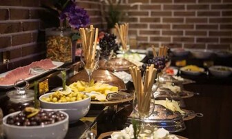 Mesa de buffet com diversos alimentos e utensílios.