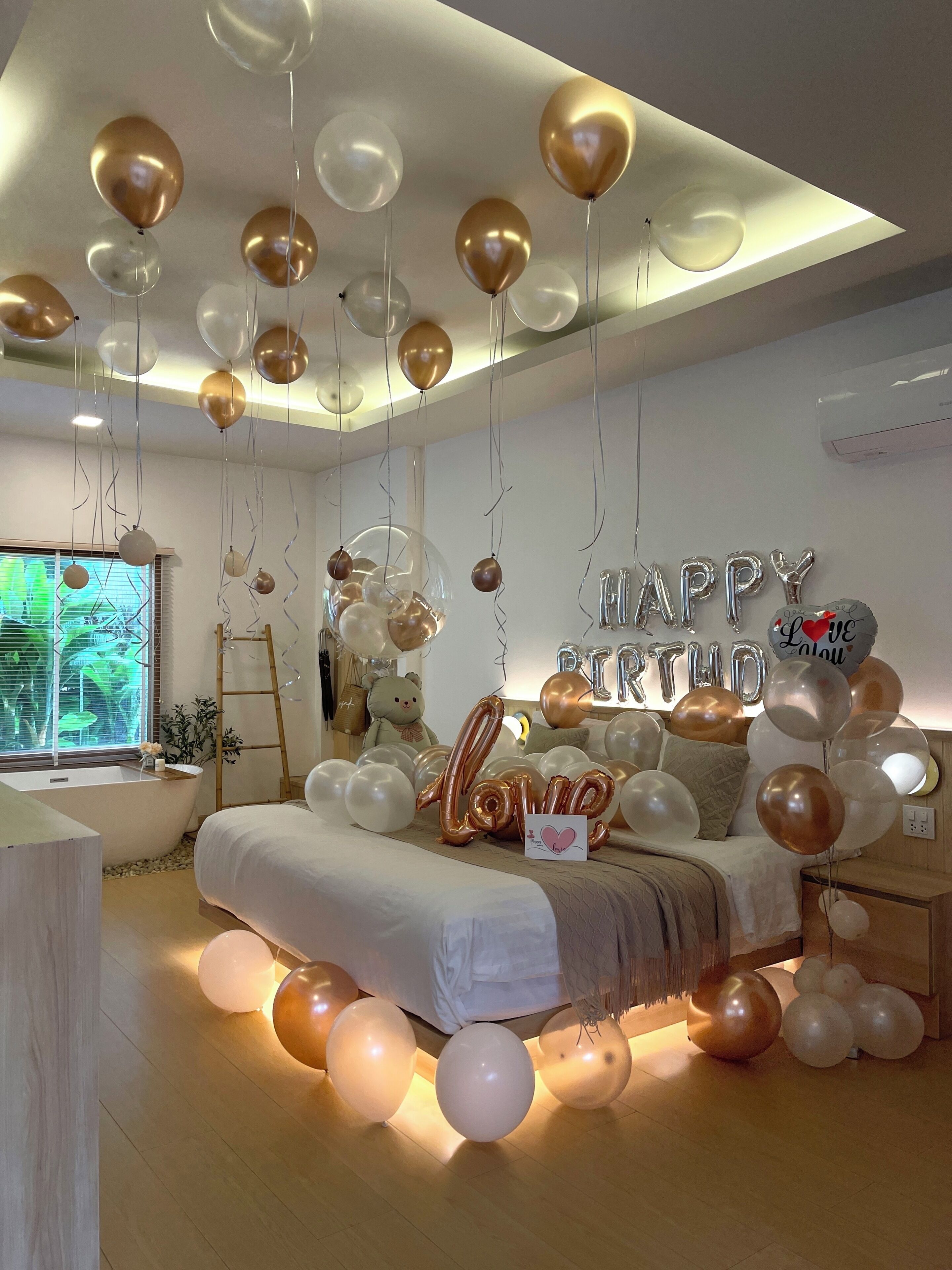 Quarto com cama, janela e balões.
