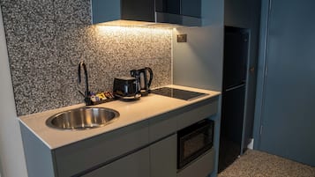 Um frigorífico, um micro-ondas, uma cafeteira/bule