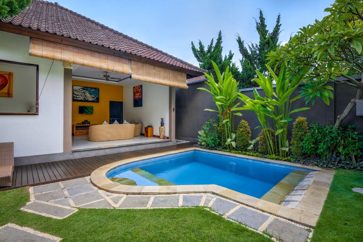 Uma casa moderna com piscina, varanda coberta e um jardim bem cuidado.