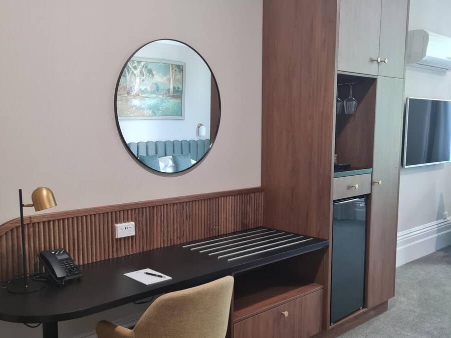 Quarto com escrivaninha, cadeira e guarda-roupa.