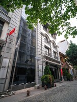 Um hotel com fachada moderna, janelas amplas e uma placa indicando ser um hotel.