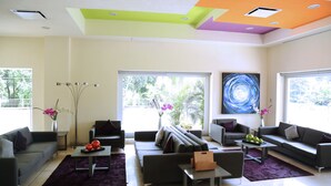 Uma sala de estar moderna com um sofá modular, uma mesa de centro e um quadro na parede.
