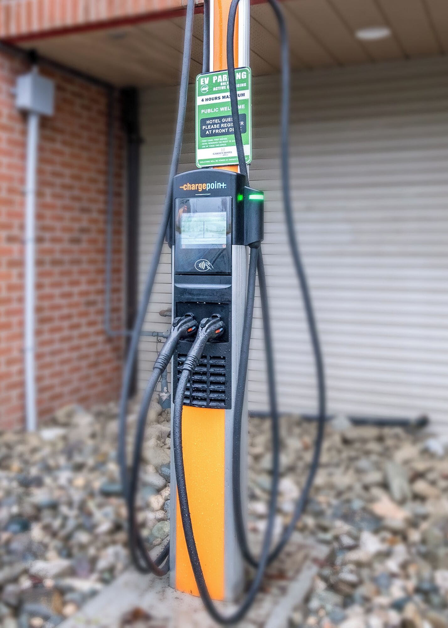 Uma estação de carregamento para veículos elétricos com placa indicando limite máximo de estacionamento de 4 horas.