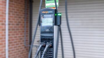 Uma estação de carregamento para veículos elétricos com placa indicando limite máximo de estacionamento de 4 horas.