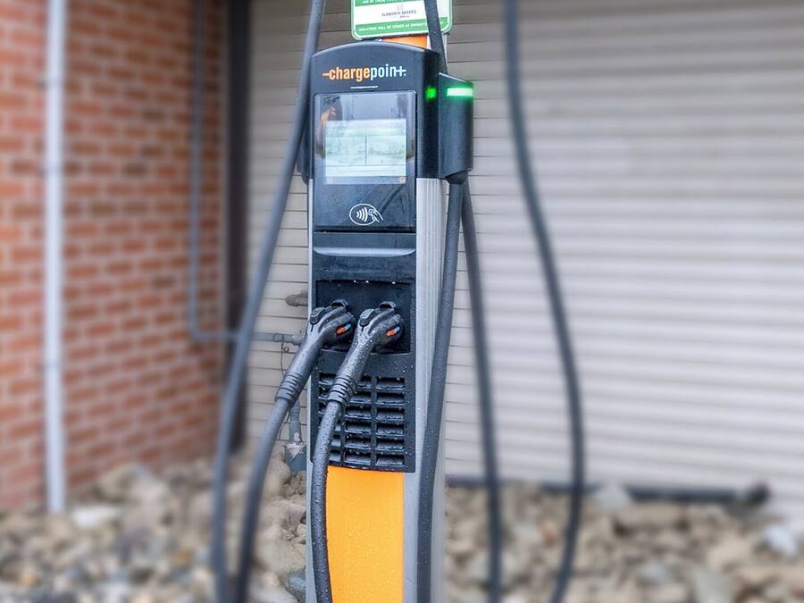 Uma estação de carregamento para veículos elétricos com placa indicando limite máximo de estacionamento de 4 horas.