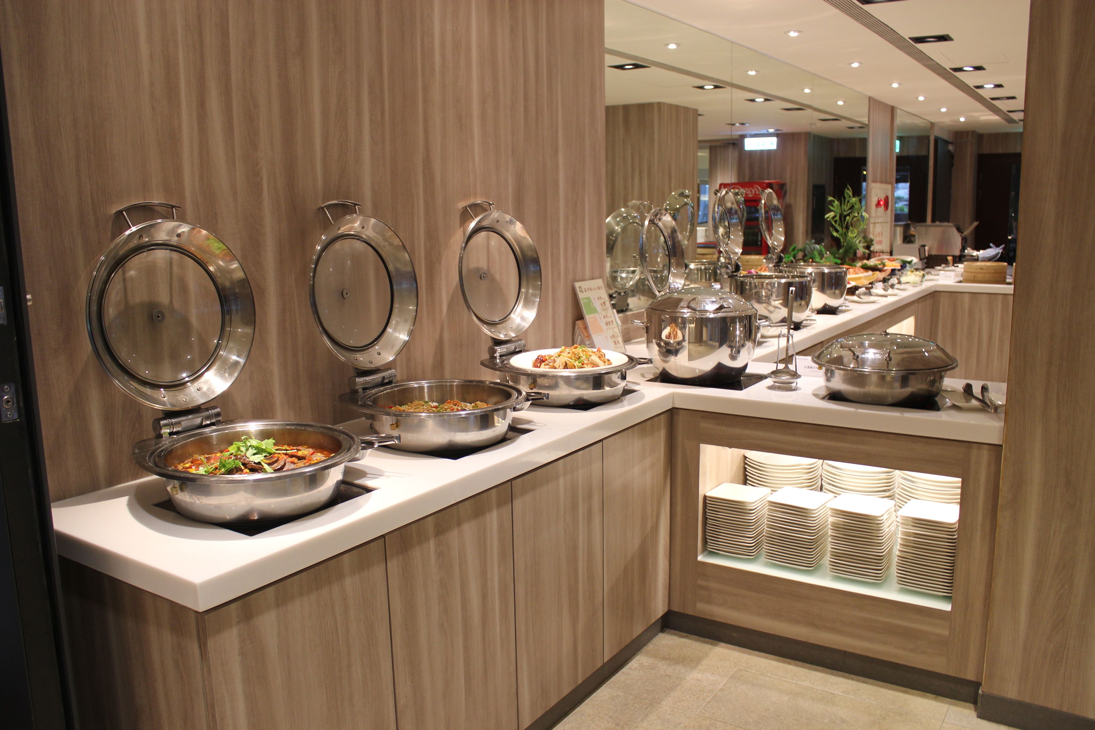 Disposição de buffet com diversos pratos e utensílios.