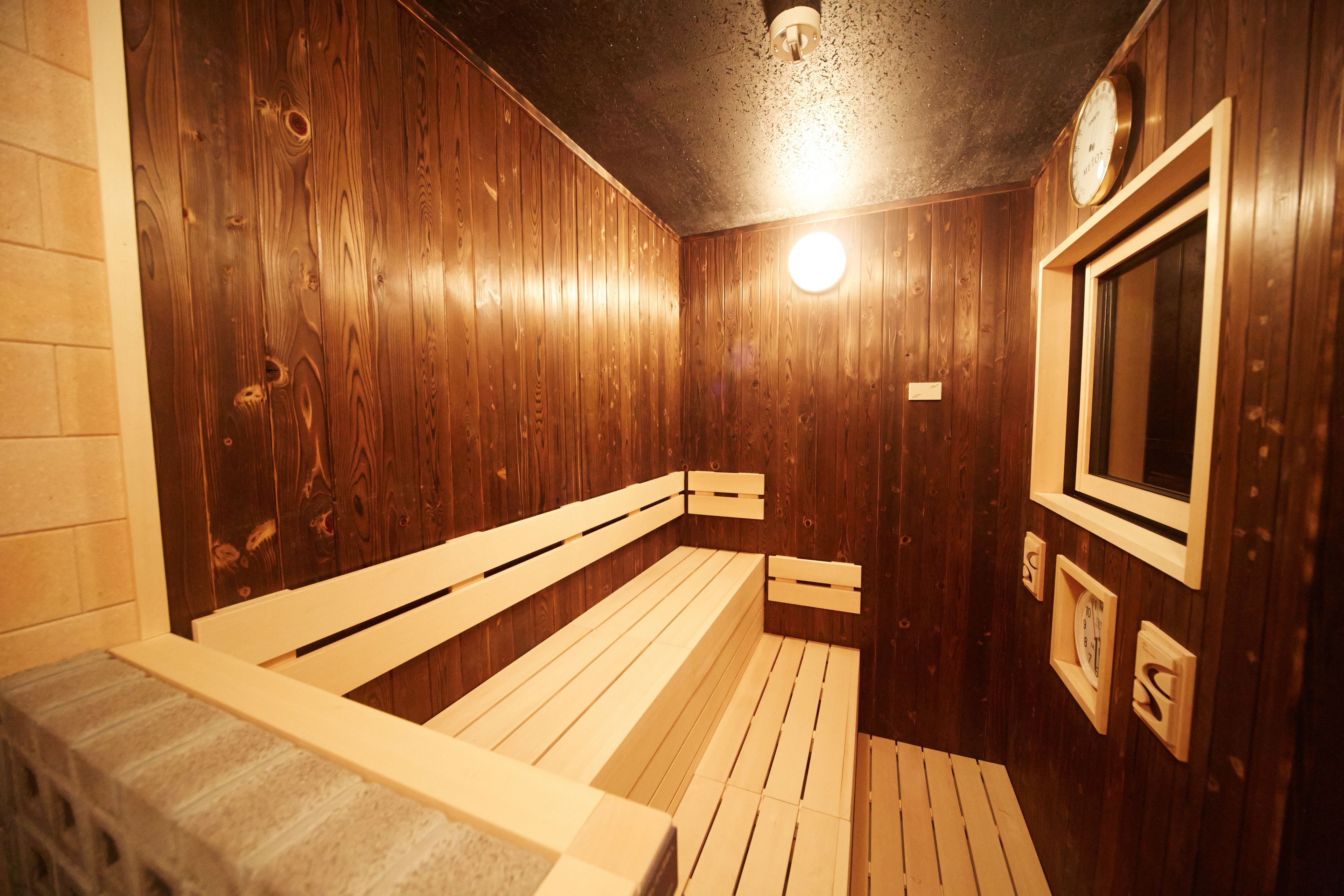 Uma sala de sauna com paredes e bancos de madeira.