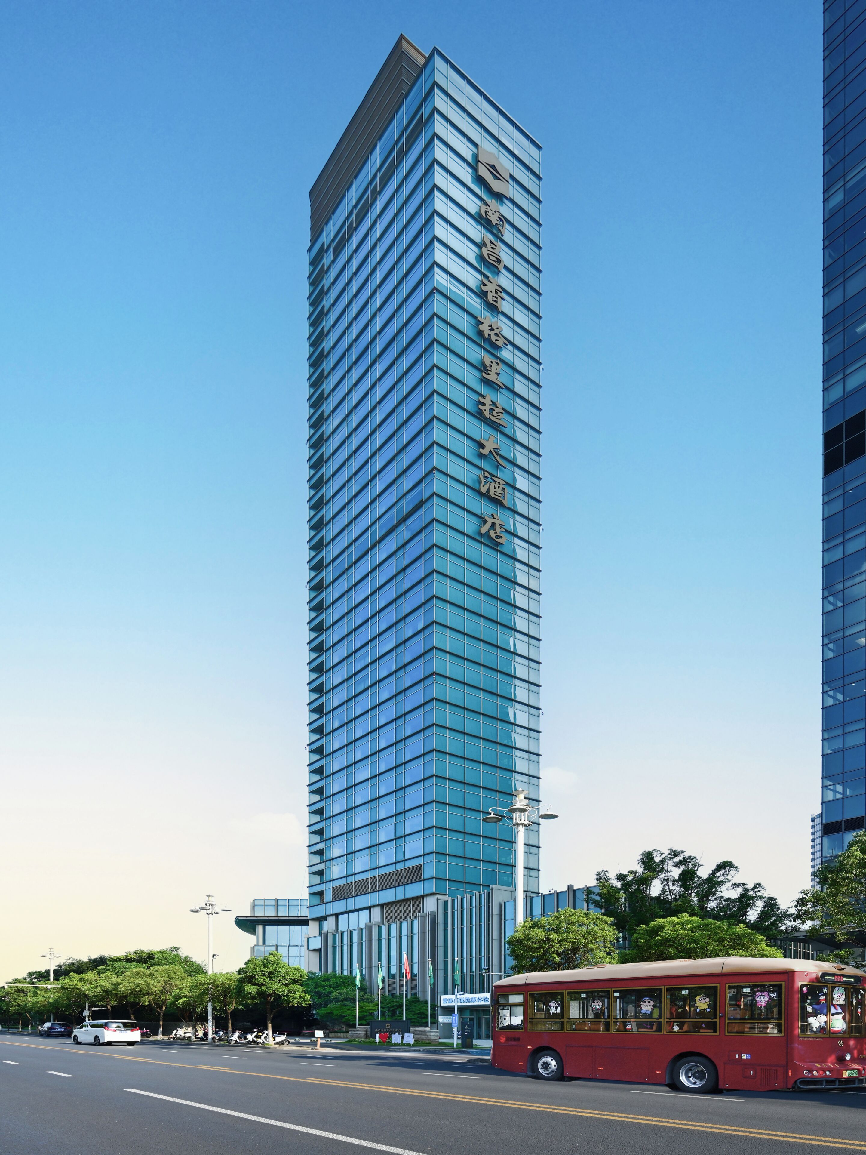 Um edifício alto e moderno com fachada de vidro e uma placa de destaque.