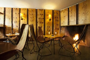 Uma sala de jantar acolhedora com painéis de madeira, lareira e mobiliário moderno.