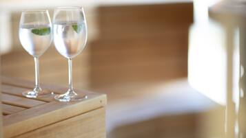 Dois copos de água sobre um banco de madeira em um quarto com parede e janela de madeira.