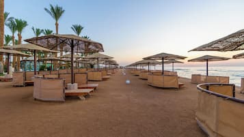 Praia particular, espreguiçadeiras, guarda-sóis, toalhas de praia