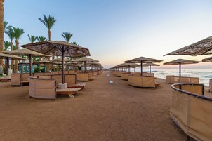 Praia particular, espreguiçadeiras, guarda-sóis, toalhas de praia