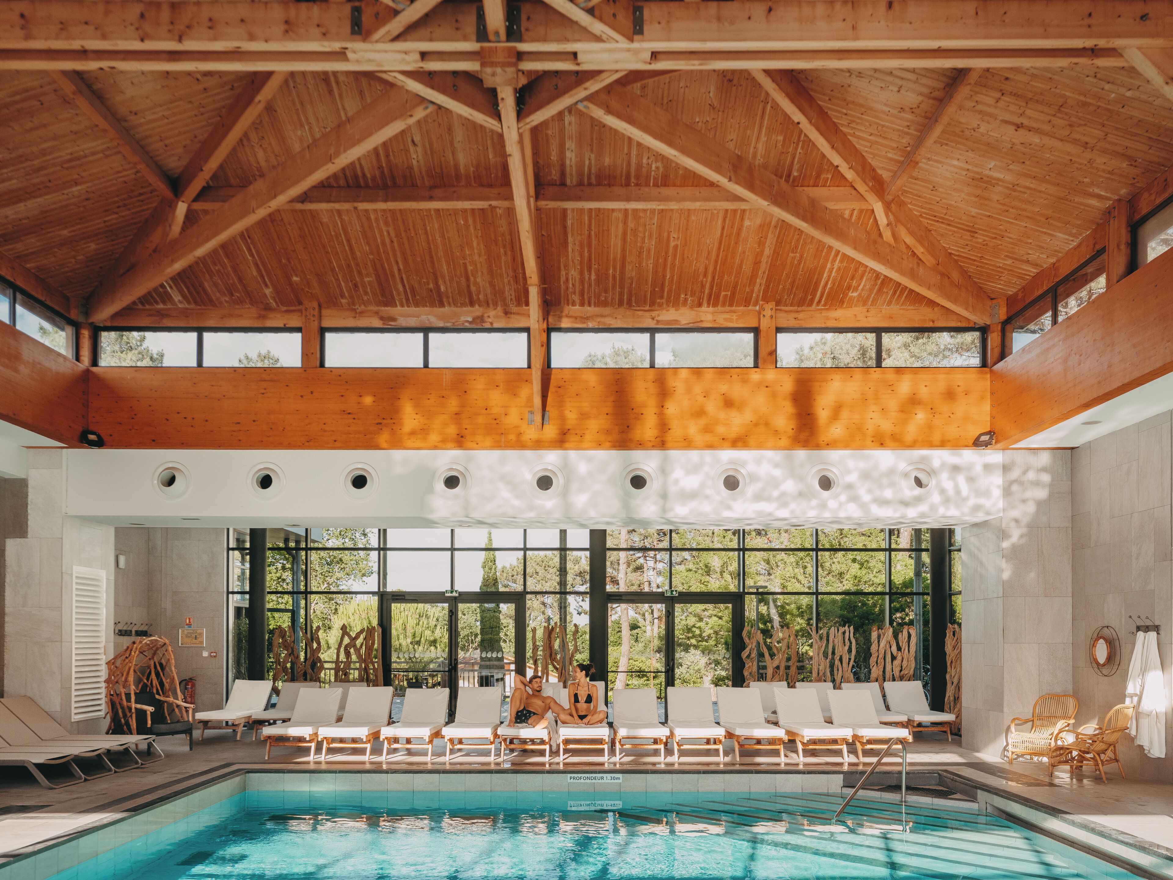 Piscina com espreguiçadeiras e cobertura.
