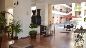 Um hall amplo com área de piscina, assentos e plantas em vasos.