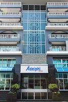 Um edifício de vários andares com uma placa de destaque que diz 'Adelphi' e 'Patav'.