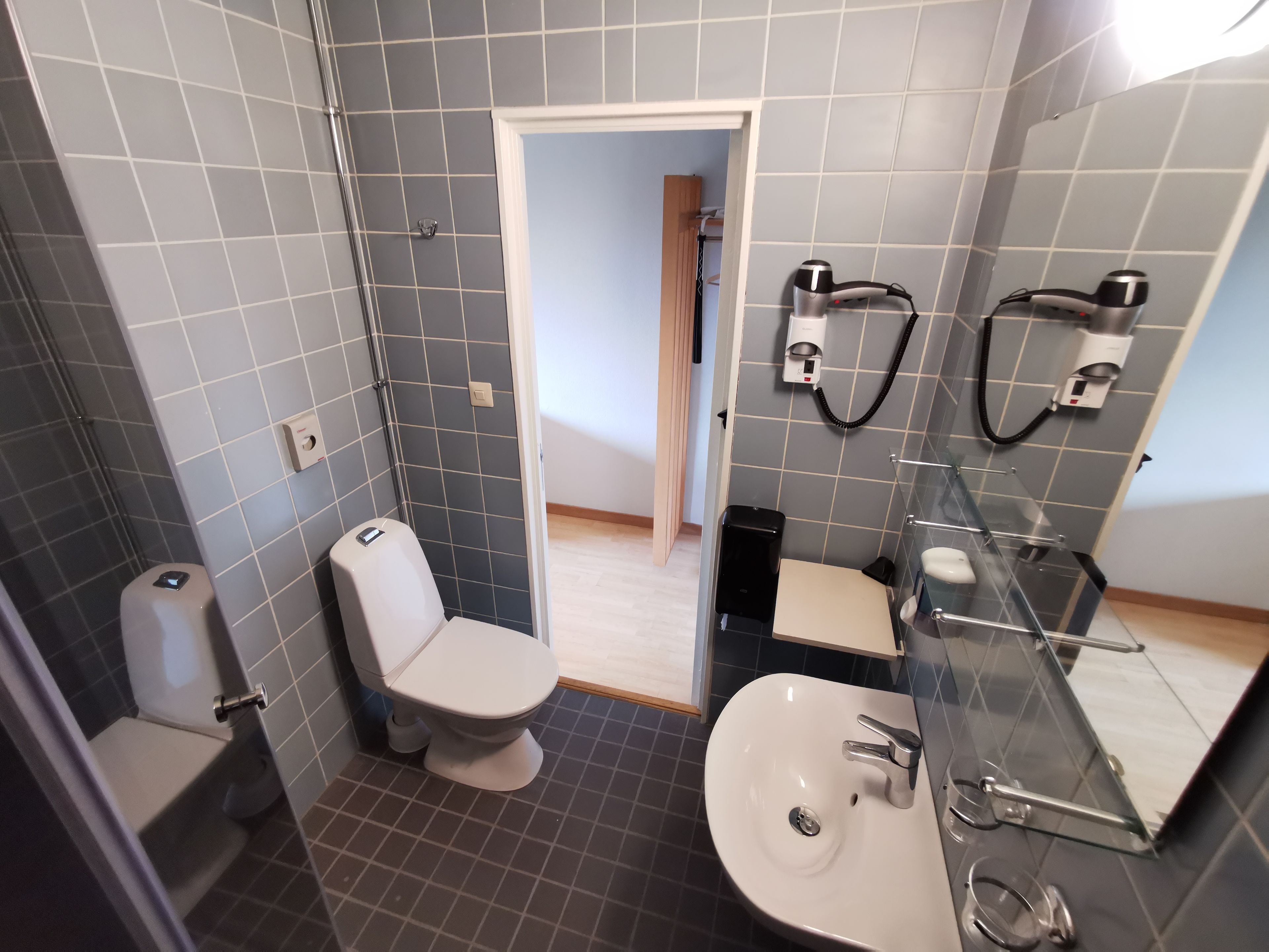 Casa de banho moderna com sanita, bidé e lavatório com cabine de vidro.