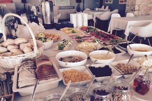 Buffet com diversos alimentos e utensílios.