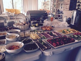 Buffet com diversos alimentos e uma máquina de café.