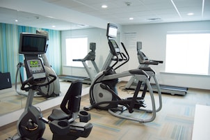 Centro de ginástica com esteiras, elípticos e bicicleta ergométrica.