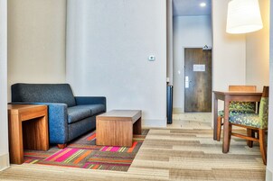 Uma sala de estar moderna com um sofá, uma mesa de centro e um tapete estampado.