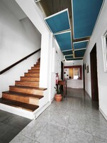Escadaria que leva a um patamar com piso de azulejos e um vaso de planta.