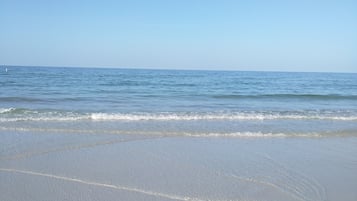 Perto da praia, praia de areia branca, guarda-sóis de praia