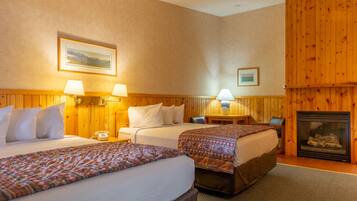Quarto de hotel com duas camas, painéis de madeira, lareira e uma moldura na parede.